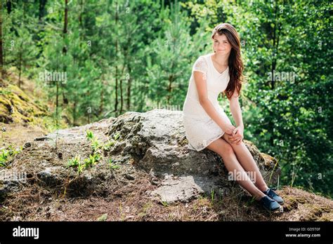 Beautiful Cute Young Smiling Woman Girl In White Dress Sitting On Stone