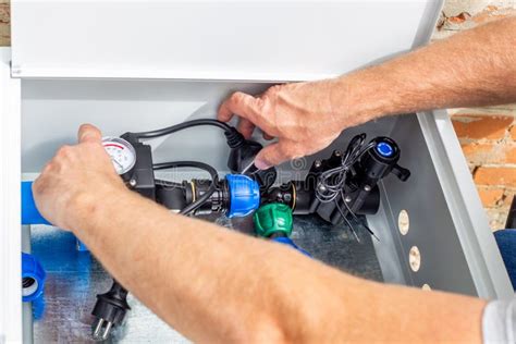 Installation Of A Drip Irrigation System A Man Assembles A System For Automatic Regulation Of