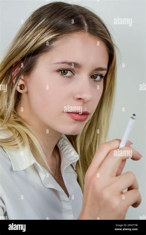 Portrait Of A Beautiful Young Blonde Woman Who Is Smoking A Cigarette