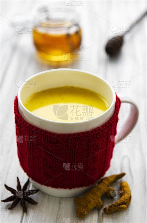 黄姜黄拿铁饮料金色牛奶与肉桂姜黄生姜和蜂蜜在白色木质背景