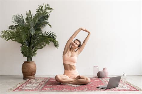 연꽃 자세를 취한 여성이 카펫 위에서 스트레칭을 하는 모습은 노트북에 대한 튜토리얼에 이어 카페트에 대한 스톡 사진 및 기타 이미지 카페트 요가 사람들 Istock