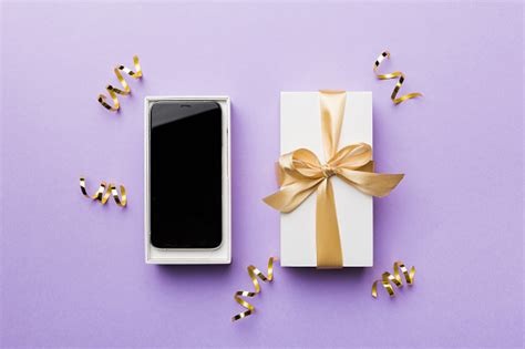 골드 리본과 스마트폰이 있는 기프트 박스를 컬러 배경 상단 보기로 오픈했습니다 빈 오픈 박스 포장 모형 디자인템플릿 브랜딩 모형
