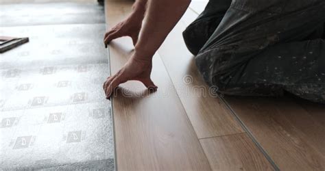 Worker Lays Laminate On A Black Backing Technology And Process Repair Of The Floor Of The