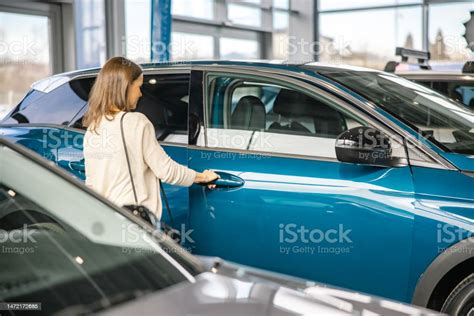 성인 여자는 자동차 딜러 앞에 있는 차에 실내에서 새 차의 문을 열고 있다 차에 대한 스톡 사진 및 기타 이미지 차 파란색 구매 Istock