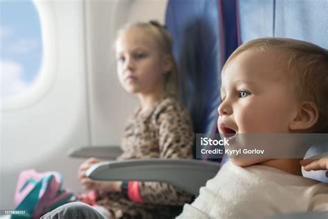 비행기로 여행 귀여운 사랑스러운 형제 남매의 쌍 소년과 소녀는 비행 중에 항공기 안에 앉아있다 테이블로 만화를 보는 아이들 행복한 가족 여행 컨셉 2 3 살에 대한 스톡