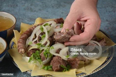 베쉬바르막 고기와 파스타로 준비된 국립 카자흐 요리 베쉬바막 접시가 테이블의 접시에 클로즈업합니다 삶은 고기와 양파의 큰 조각