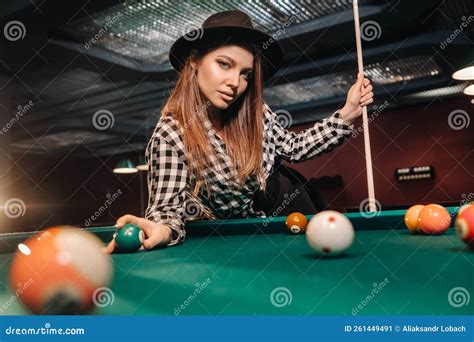 A Girl In A Hat In A Billiard Club With A Cue And Balls In Her Handsplaying Pool Stock Image