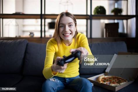 귀여운 소녀는 콘솔에서 게임을 재생 하 고 피자를 먹는다 비디오 게임에 대한 스톡 사진 및 기타 이미지 비디오 게임 노랑 미소 Istock
