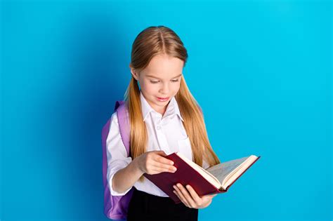 교복을 입은 어린 여학생이 학습 교육 및 지식을 상징하는 파란색 배경에 책을 읽고 있습니다 6 7 살에 대한 스톡 사진 및 기타 이미지 Istock