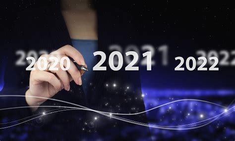 컨셉 은 새해 시작 2022 손 디지털 그래픽 펜을 들고 도시 어두운 흐린 배경에 디지털 홀로그램 2021 사인을 그리기 성공