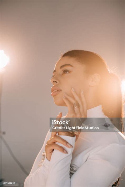 스포트 라이트와 함께 스튜디오에서 포즈를 취하는 아프리카계 미국인 여성 모델의 사이드 보기 사람들에 대한 스톡 사진 및 기타