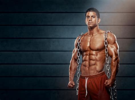 그의 어깨에 큰 사슬을 가진 강한 근육질의 남자 프리미엄 사진