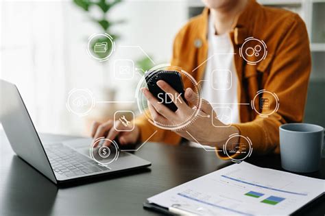 Sdk 소프트웨어 개발 키트 프로그래밍 언어 기술 개념 가상 화면에 Sdk 아이콘이 있는 노트북 컴퓨터 및 태블릿을 입력하는 사람 사무실에서 Brand Name Video