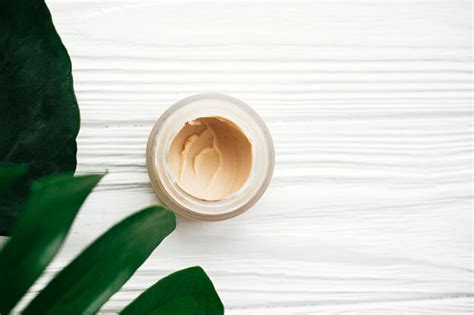 자연 환경 친화적인 치약 유리 데오도란트 크림 또는 버터 그린 몬스 테라와 하얀 나무에 나뭇잎 제로 폐기물 개념입니다 에코 제품 플라스틱 무료입니다 관리 및 치료 웰빙에