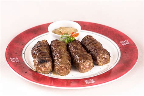 Mici 전통적인 루마니아어 고기 롤 겨자와 함께 녹색 및 빨강 잎으로 장식 백색과 빨강 접시 밝은 배경에 배치 루마니아에 대한 스톡 사진 및 기타 이미지 Istock