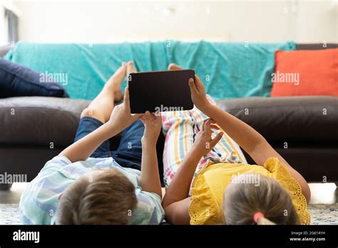 Caucasian Brother And Babe Using Tablet With Blank Screen Lying On Floor At Home Stock Photo