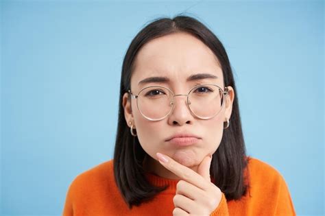 Free Photo Close Up Of Asian Woman In Glasses Thinking Staring At Camera With Thoughtful Face