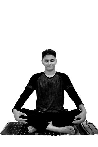 흰색에 고립 된 검은 색 활동복 복장에 남성 십대의 전체 길이 샷과 교차 다리와 연꽃 포즈 요가 또는 Padmasana 요가 운동을하고 검은색에 대한 스톡 사진 및 기타