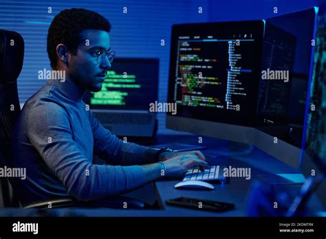 Young Serious Software Developer Typing On Desktop Keyboard While