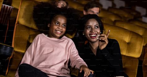 여자는 영화관에서 딸과 함께 웃고 웃으며 영화를 보는 것을 즐긴다 사진 Unsplash의 사람 이미지