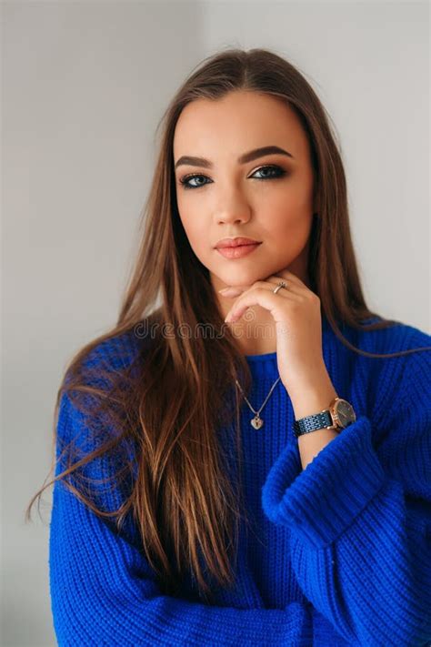 Beautiful Brunette Girl With A Lovely Smile In A Blue Blouse Posing For