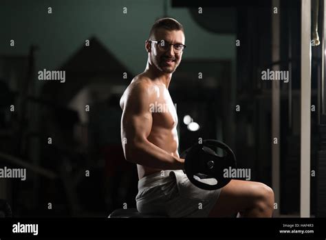 Muscular Nerd Man Doing Heavy Weight Exercise For Biceps With Barbell