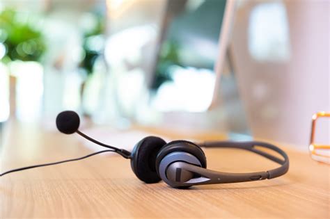 고객 서비스 및 마케팅 지원 작업장에서 컴퓨터 바탕 화면이 있는 책상 위의 헤드셋 고객 서비스의 사무용품 커뮤니케이션 지원 콜