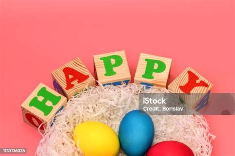다섯 부활절 색 계란은 부드럽게 분홍색 배경에 행복 단어와 큐브의 상단에 둥지에 거짓말 가로 사진입니다 관대함에 대한 스톡 사진 및 기타 이미지 Istock