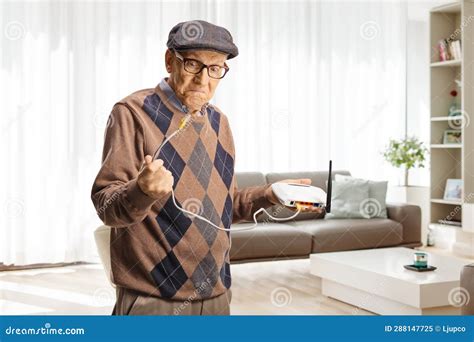 Irritated Older Man Holding A Router Cable At Home Stock Image Image Of Grimace Internet