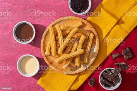 테이블에 츄러스가 있는 분홍색 배경 플레이트 츄러스가 있는 접시의 평면도 흰색 세라믹 그릇에 다양한 토핑 근처의 테이블 Launch Party에 대한 스톡 사진 및 기타