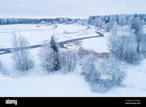 Aerial Of A Frosty And Snowy Rural Landscape With A Open River In