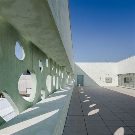 Perforated green cladding wraps science university by Cláudio Vilarinho