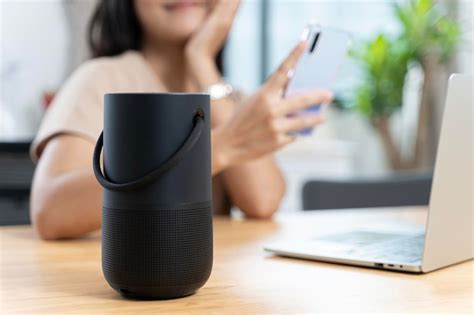 Premium Photo Closeup On Hand Using Phone Connecting Portable Speaker Black Portable Wireless