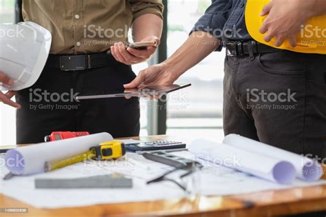 아시아 엔지니어들은 비용 견적을 문서화하고 주택 및 건물의 건축 및 엔지니어링 설계를 위한 평면도를 작성하기 위해 브레인스토밍 및 측정합니다 2명에 대한 스톡 사진 및 기타