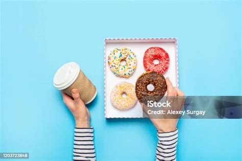 여성의 손이 파란색 배경에 도넛과 커피 한 잔을 들고있다 컨셉 제과 점 패스트리 커피 숍 배너 플랫 레이 상단 보기 끈적거리는에 대한 스톡 사진 및 기타 이미지 Istock