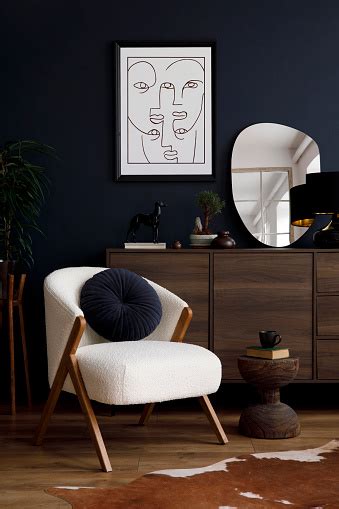 푹신한 안락의자 나무 콤모드 모의 포스터 프레임 거울 및 현대적인 홈 액세서리가있는 현대적인 거실 인테리어 구성 파란색 벽 템플렛 공간을 복사합니다 0명에 대한 스톡 사진