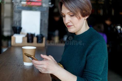 Beautiful Cute Girl In The Cafe Near The Window With Coffee Smiling