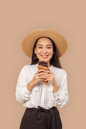 자유형 젊은 여자 에 셔츠 과 모자 서 고립 에 가방 먹는 초콜릿 바 미소 즐거운 갈색 머리에 대한 스톡 사진 및 기타 이미지 갈색 머리 건강한 생활방식 건강한