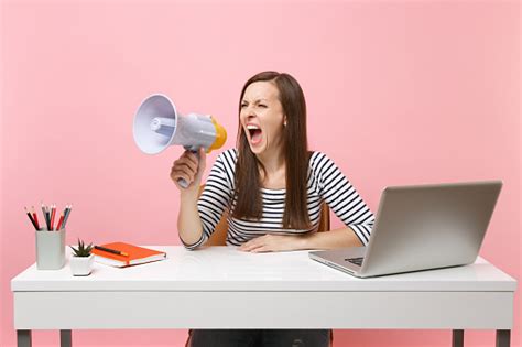 적극적인 여 자가 사무실에서 Pc 노트북 파스텔 핑크 배경에 고립 프로젝트에 노력 하 고 앉아 동안 확성기에 비명 성과 비즈니스 경력 개념입니다 광고에 대 한 공간을 복사