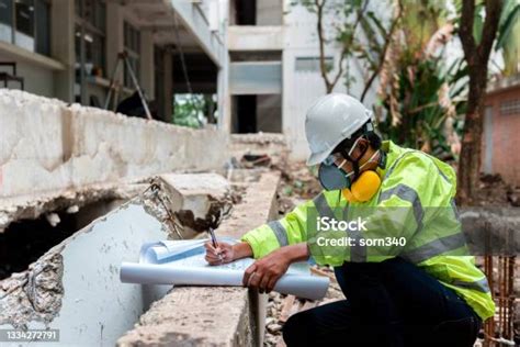 건설 현장의 종이 를 그리는 동안 토목 엔지니어 사람들은 얼굴 마스크와 안전 헬멧을 착용하고 있습니다 철거 및 리노베이션을 위한 건설 건물에서 측량 및 점검 건설업자에 대한