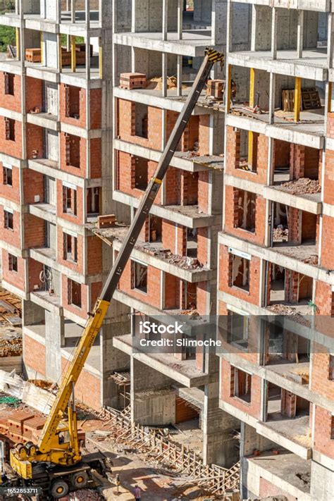크레인이 붉은 벽돌 블록을 주거용 건물 건설 현장의 꼭대기로 들어 올립니다 0명에 대한 스톡 사진 및 기타 이미지 0명 강철 건설 기계류 Istock