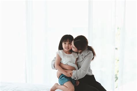 침실에서 즐거운 가족 어머니 딸 함께 시간을 보내고 침대에서 엄마와 놀고있는 어린 소녀 엄마키스 부모와 아이는 집에서 함께 좋은