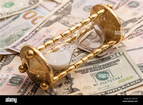 Hourglass And Us Dollar Banknotes Concept Of Investment And Inflation