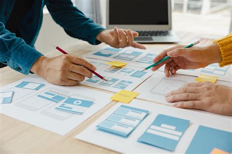 Ux 개발자와 Ui 디자이너가 현대 사무실에서 고객 요약 및 색상 코드와 함께 테이블에 모바일 앱 인터페이스 와이어프레임