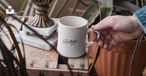 갈색 테이블 램프 근처에 흰색 세라믹 머그잔을 들고 있는 사람 사진 Unsplash의 무료 커피숍 이미지