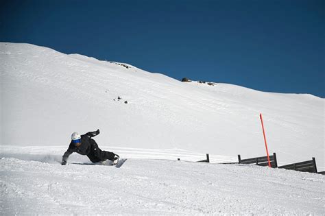 눈 덮인 슬로프를 따라 스노보드를 타고 내려가는 남자 사진 Unsplash의 무료 다보스 이미지