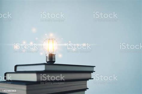 책이나 교과서가있는 빛나는 전구 또는 밝은 램프 학생 또는 사업가를위한 기술 향상 집에서 온라인으로 공부하고 훈련 과정 사업 성공 아이디어 교육 학습 개념 학습에 대한 스톡
