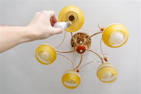 Premium Photo Hand Screwing New Lightbulb Into Ceiling Lamp