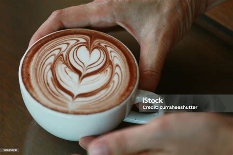 라떼 아트를 만들기 위해 커피잔에 따뜻한 우유를 붓는 바리스타의 손 커피숍에서 커피를 마시는 바리스타의 다재다능함 뜨겁고 차가운