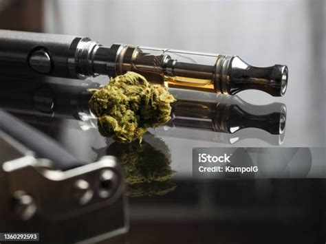 실제 마리화나 또는 대마초의 대마초 기름 배경 어두운 테마 아래 오른쪽에 전경과 텍스트 공간에 흐리게 롤러 Vape 펜의 카트리지 닫습니다 전자담배에 대한 스톡 사진 및